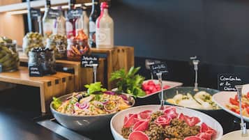 Buffet com diversos pratos, incluindo saladas, carnes e acompanhamentos.