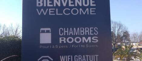 Placa do hotel Kyriad com comodidades como quartos, acesso Wi-Fi gratuito, salas de reunião e restaurante.