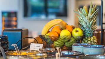 Exposição de frutas com banana, abacaxi, laranjas e maçãs.