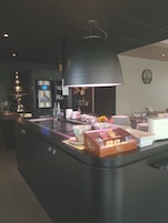 Cozinha moderna com ilha central, equipada com máquina de café, espaço para chá e diversos utensílios de cozinha.