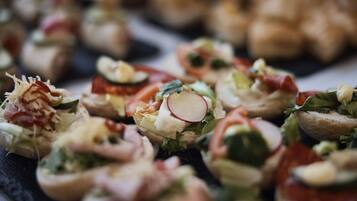 Diversos aperitivos como sushi, saladas e sanduíches.