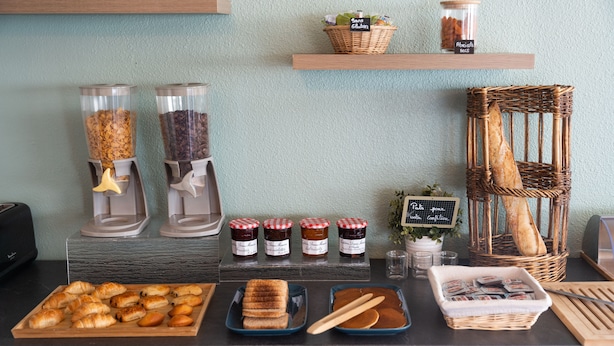 Um buffet de café da manhã com diversas opções de alimentos e acompanhamentos.