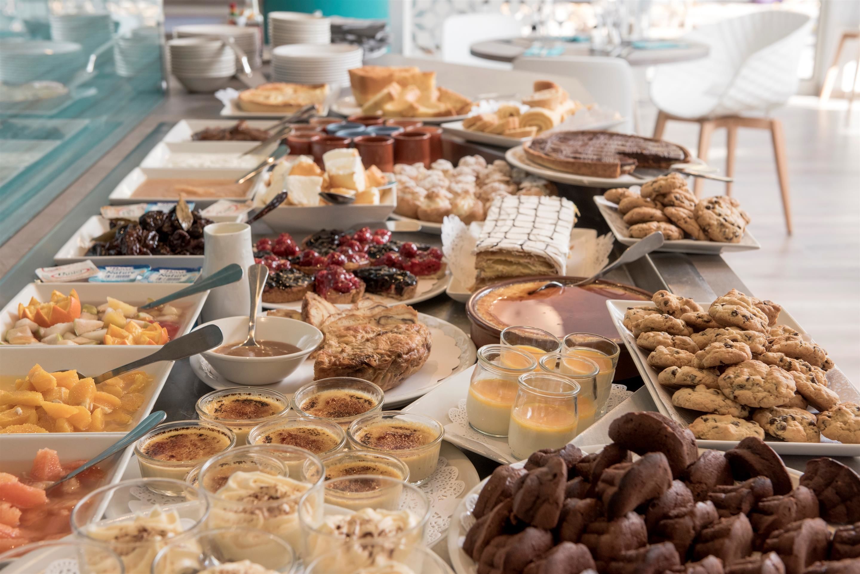 Buffet com diversos itens, incluindo doces, sobremesas e bebidas.