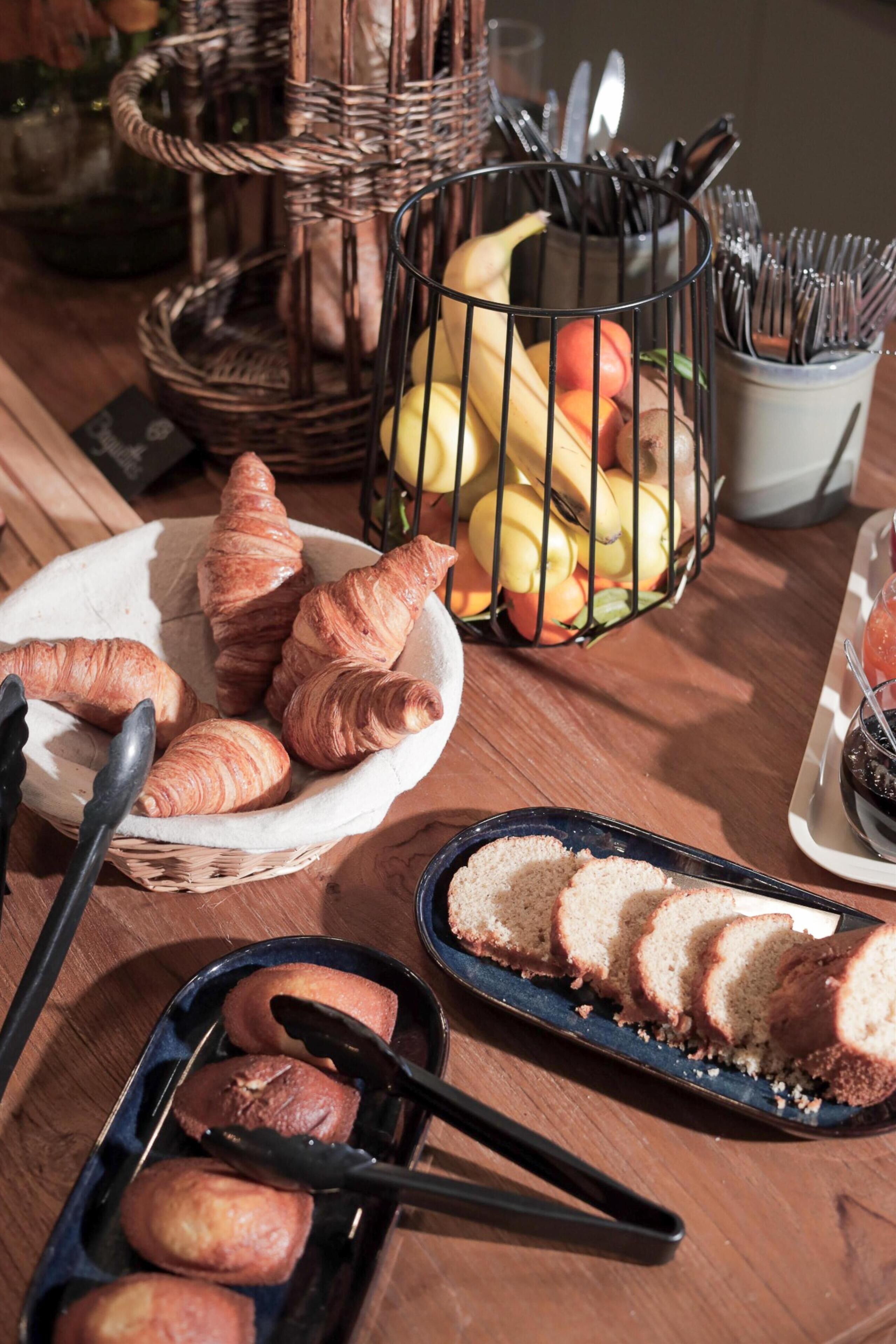 Uma mesa com doces, frutas e utensílios.