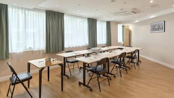 Uma sala de conferências com uma mesa comprida, cadeiras e um projetor.