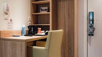 Quarto compacto com escrivaninha de madeira, uma cadeira e estantes embutidas.