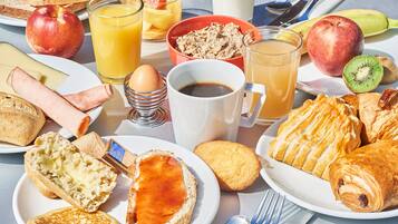 Mesa de café da manhã com diversos alimentos e bebidas.