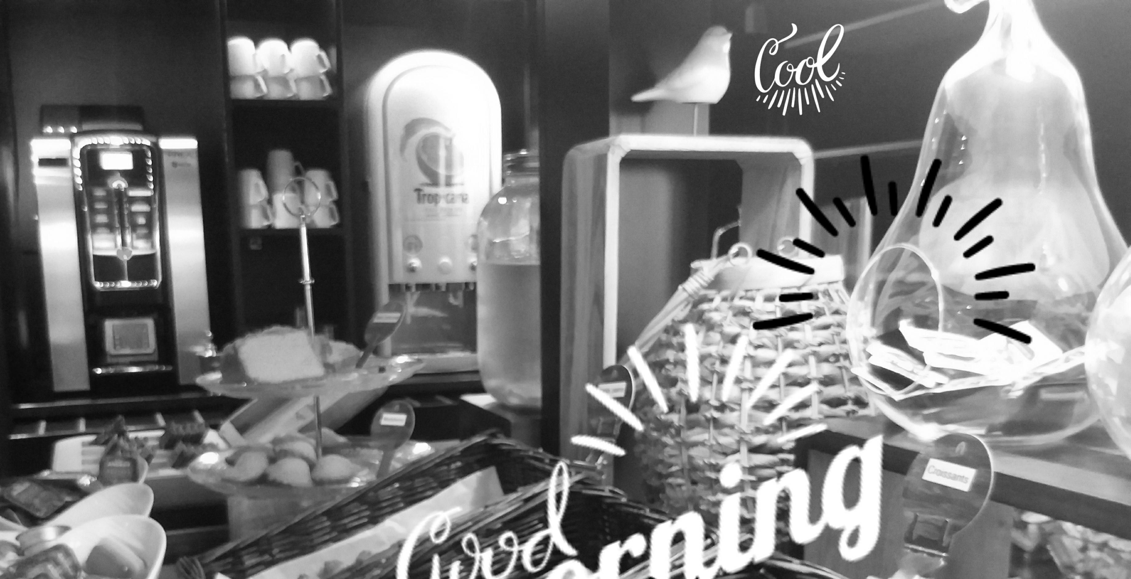 Um buffet de café da manhã com diversos alimentos e uma máquina de café.