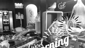 Um buffet de café da manhã com diversos alimentos e uma máquina de café.