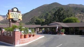 Placa do Peach Tree Inn com montanhas ao fundo.