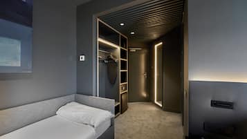 Quarto moderno com uma cama de solteiro, closet espaçoso e escrivaninha embutida.
