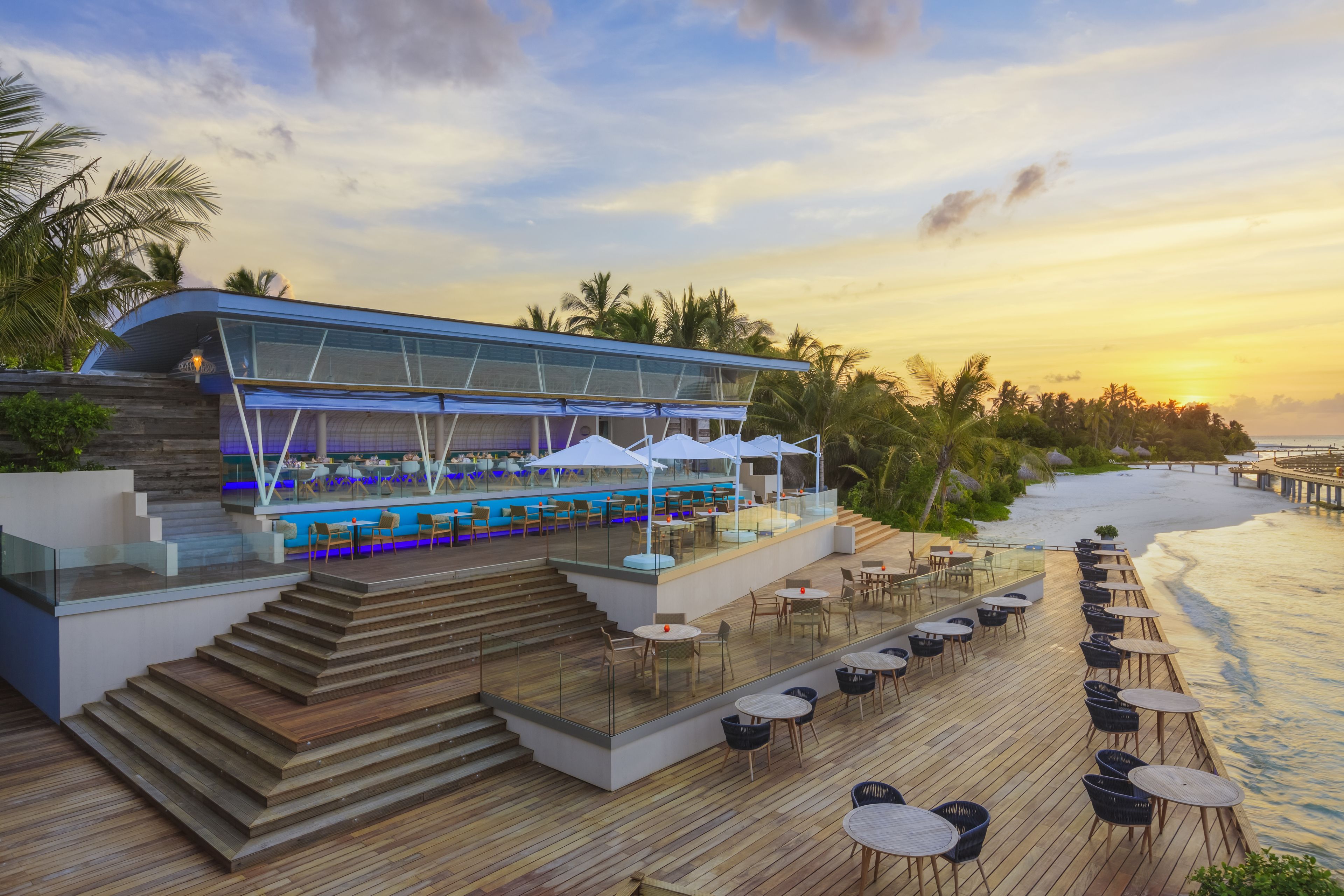 Um resort moderno com área de piscina, área de estar ao ar livre e vista para a praia.