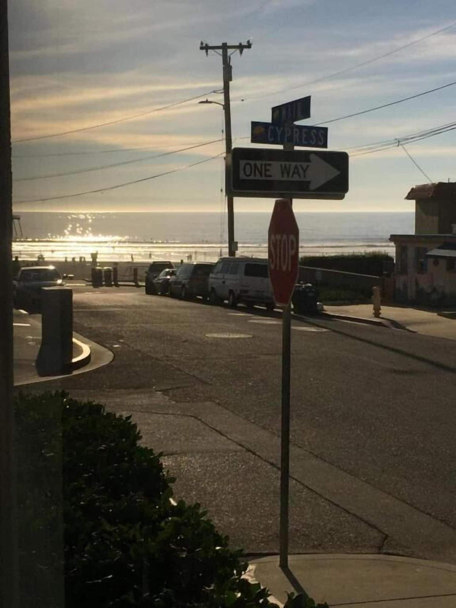 Vista da rua com uma placa de pare, uma placa de sentido único e uma placa indicando Cypress.
