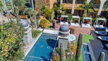 Área de piscina no terraço, com vista clara da piscina, cadeiras de descanso e vegetação ao redor.
