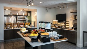Cozinha moderna com sistema de buffet, incluindo estação de café e diversos alimentos.
