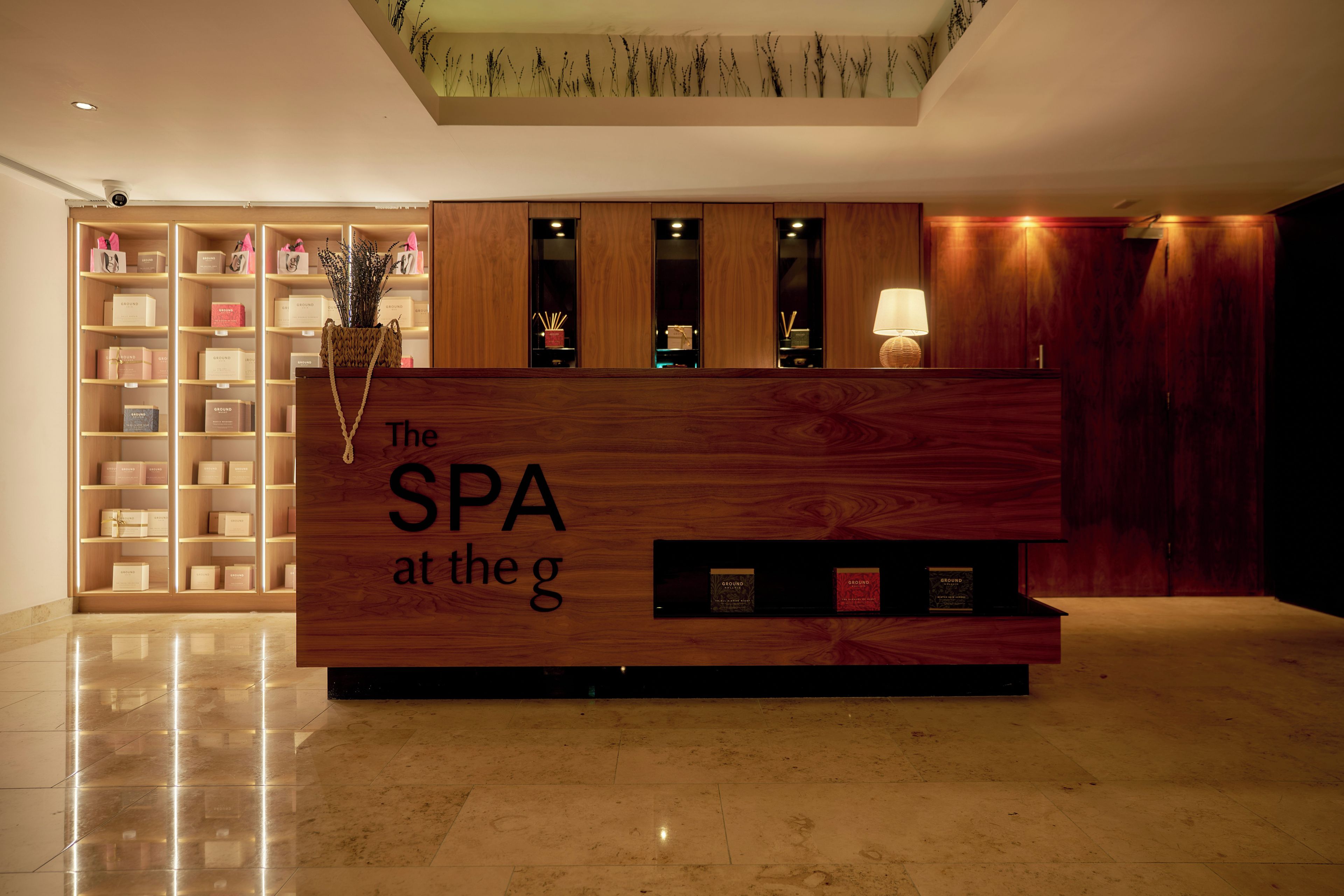 Balcão de recepção com acabamento em madeira e a inscrição 'The SPA at the g'.