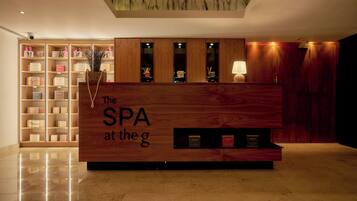 Balcão de recepção com acabamento em madeira e a inscrição 'The SPA at the g'.