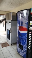 Máquina automática de bebidas com logotipo da Pepsi e dispensador de água com cubos de gelo.