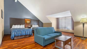 Um quarto com uma cama, um sofá, uma mesinha e uma luminária.