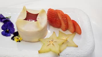 Prato de sobremesa com uma fruta em formato de estrela e uma fatia de morango.