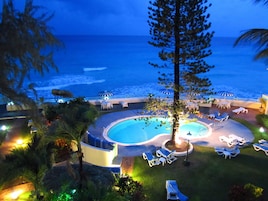 Na praia, areia branca, espreguiçadeiras, guarda-sóis