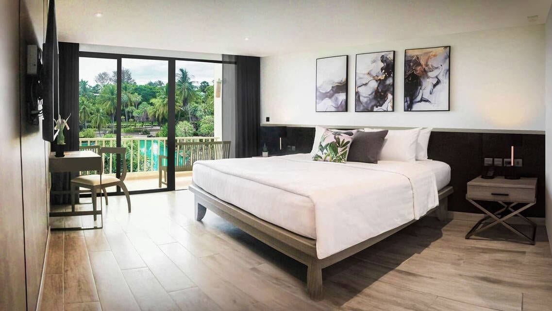 Quarto moderno com uma cama grande, escrivaninha e varanda com vista para o verde.