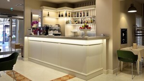 Uma área de bar com balcão, prateleiras cheias de garrafas e um espaço de estar com cadeiras.