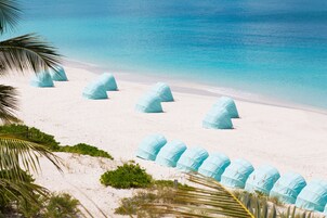 Na praia, praia de areia branca, espreguiçadeiras, toalhas de praia 