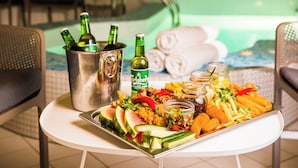 Uma bandeja com comida e bebidas em uma mesa perto da área da piscina.