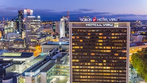 Um edifício moderno de hotel com vários andares, janelas amplas e uma placa chamativa do SOKOS HOTEL VIRU.