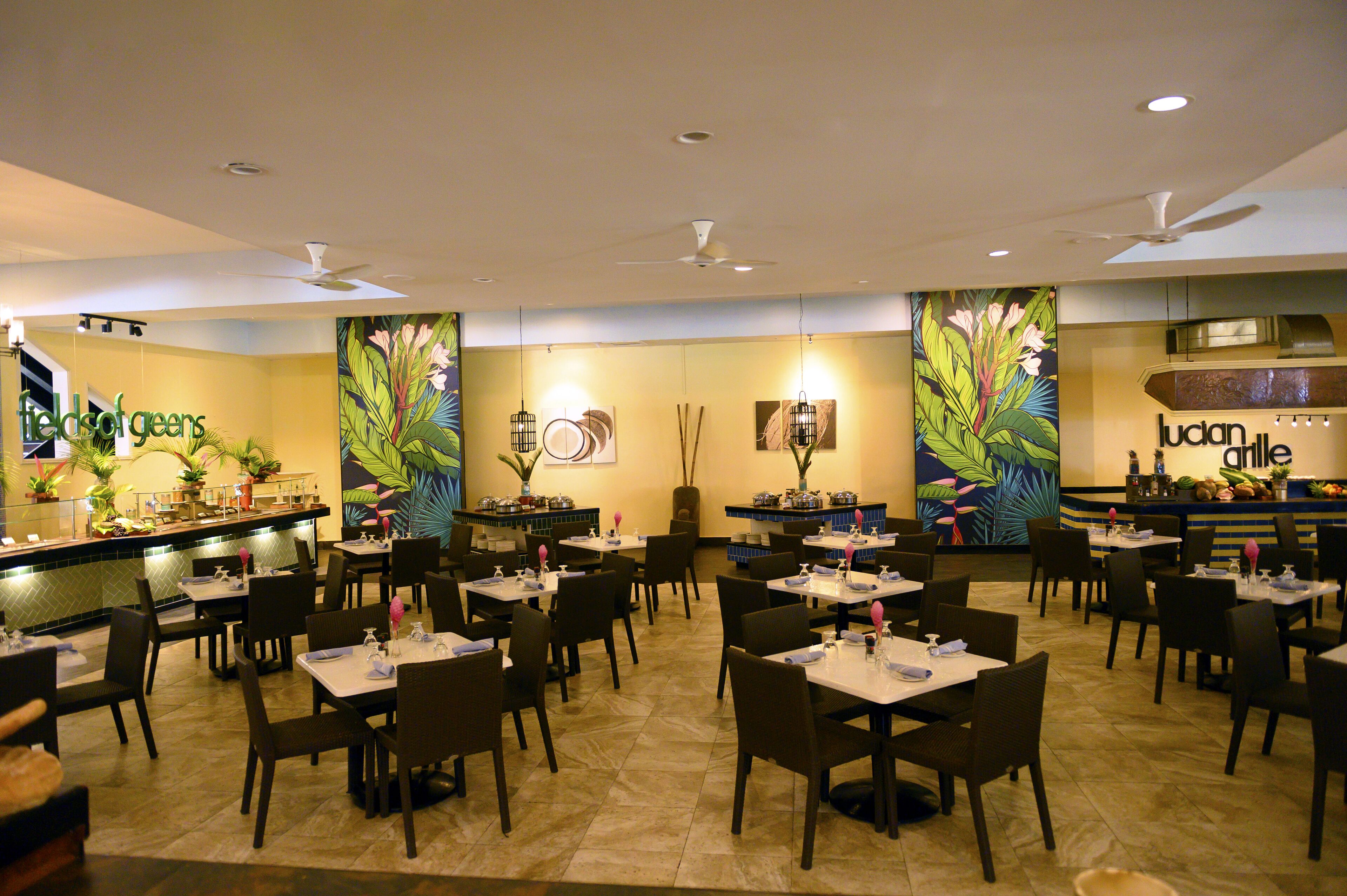 Um restaurante com várias mesas e cadeiras, um balcão com menu e arte decorativa nas paredes.