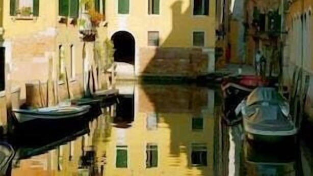 Um canal estreito com edifícios em ambos os lados e um hotel com uma placa que diz 'HOTEL DE VENICE'.