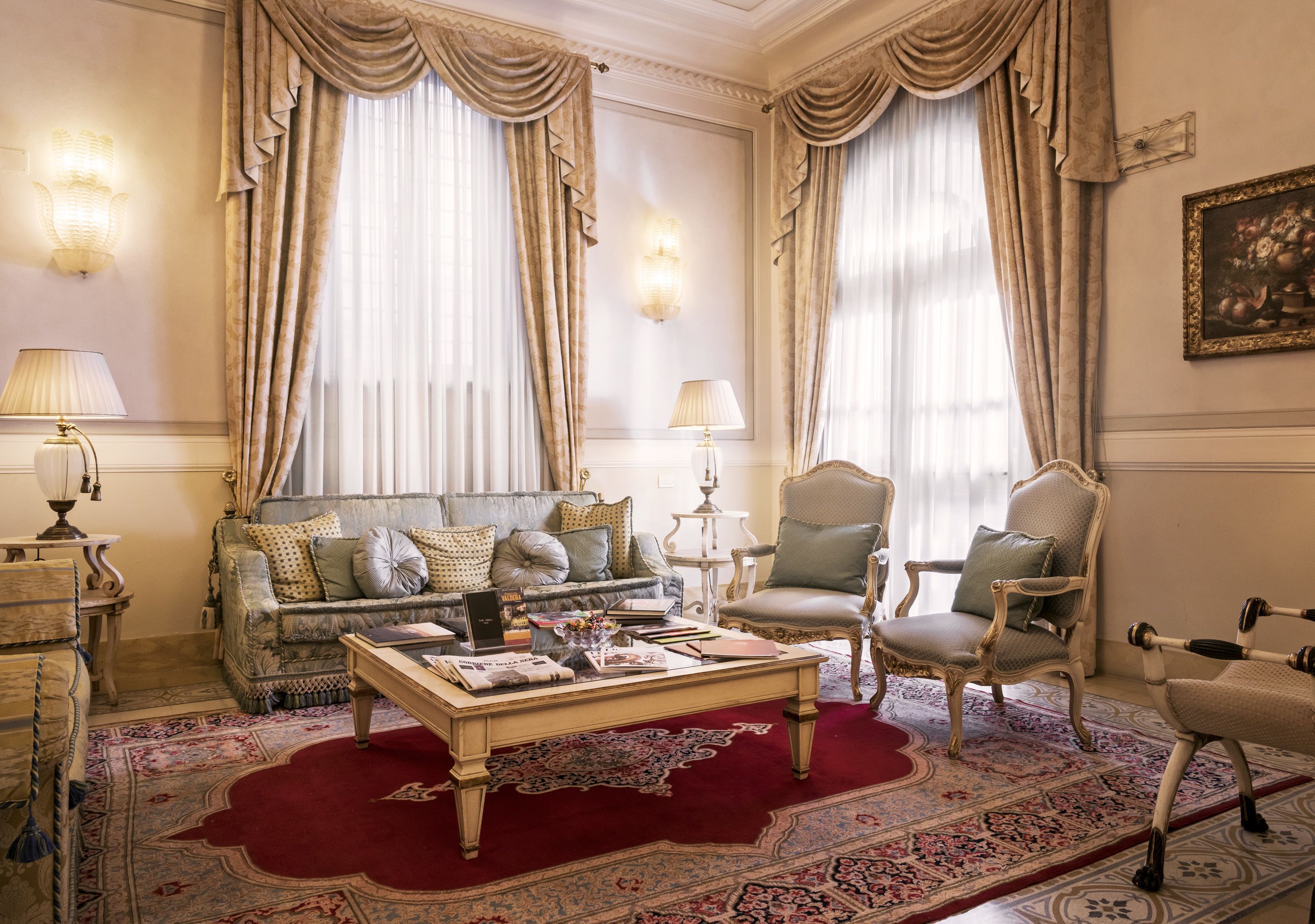 Uma sala de estar tradicional com um sofá, poltronas, uma mesa de centro e um tapete estampado.