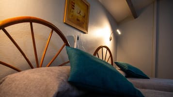 Quarto com cabeceira de madeira, um quadro na parede e uma luminária de cabeceira.