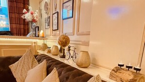 Uma sala de estar moderna com um sofá castanho escuro, almofadas estampadas, um globo e quadros nas paredes.