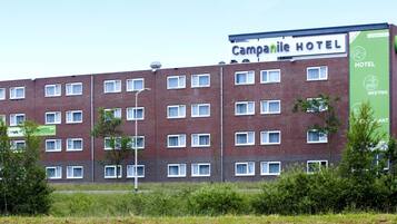 Um hotel com vários andares e uma placa grande com a inscrição 'Campanile Hotel'.