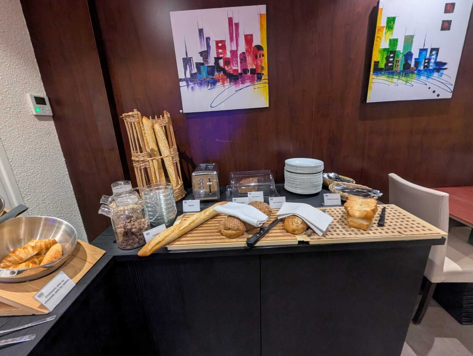 Buffet de café da manhã com pães, doces e acompanhamentos.