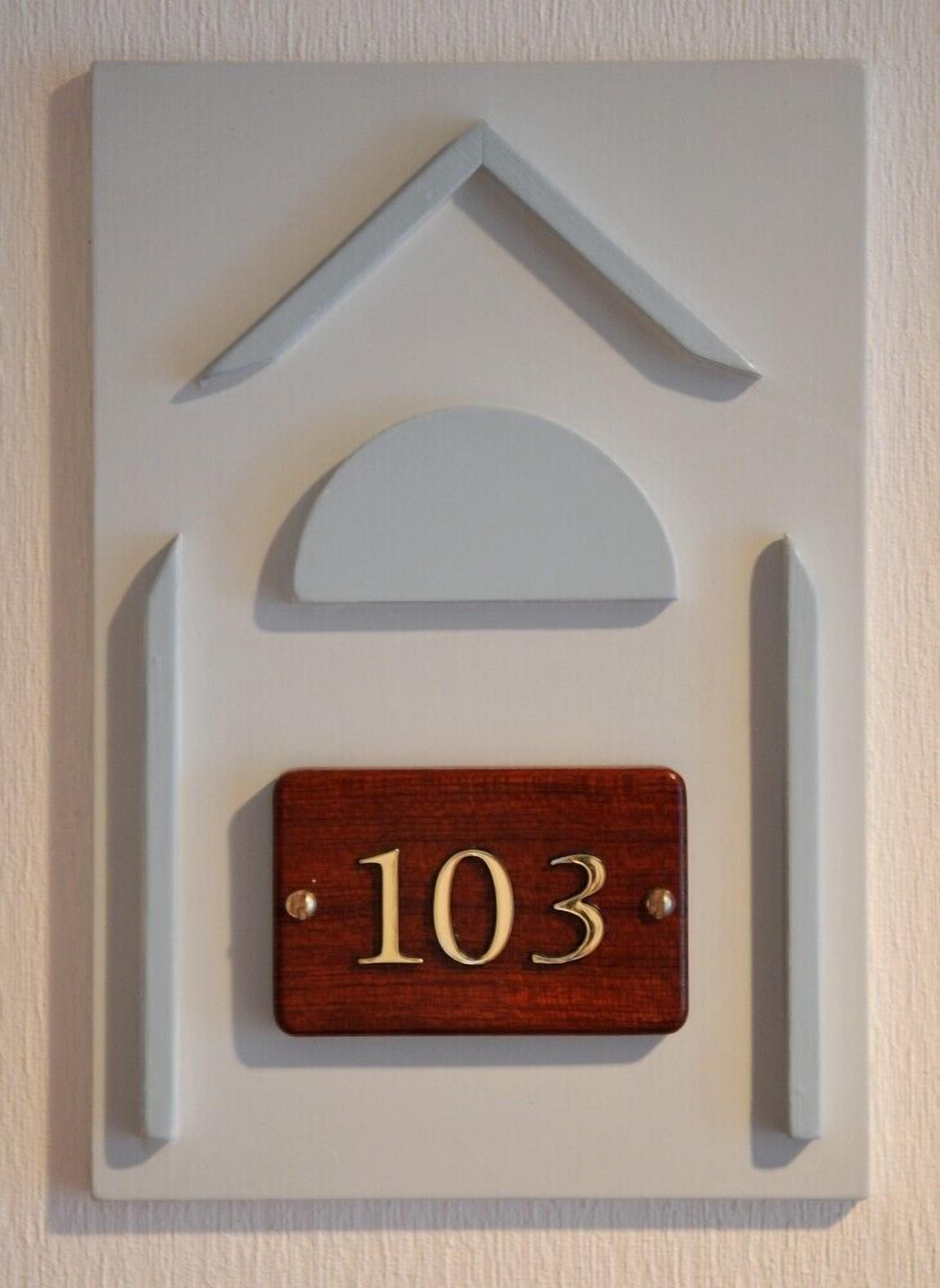 Uma placa em formato de casa com o número 103.