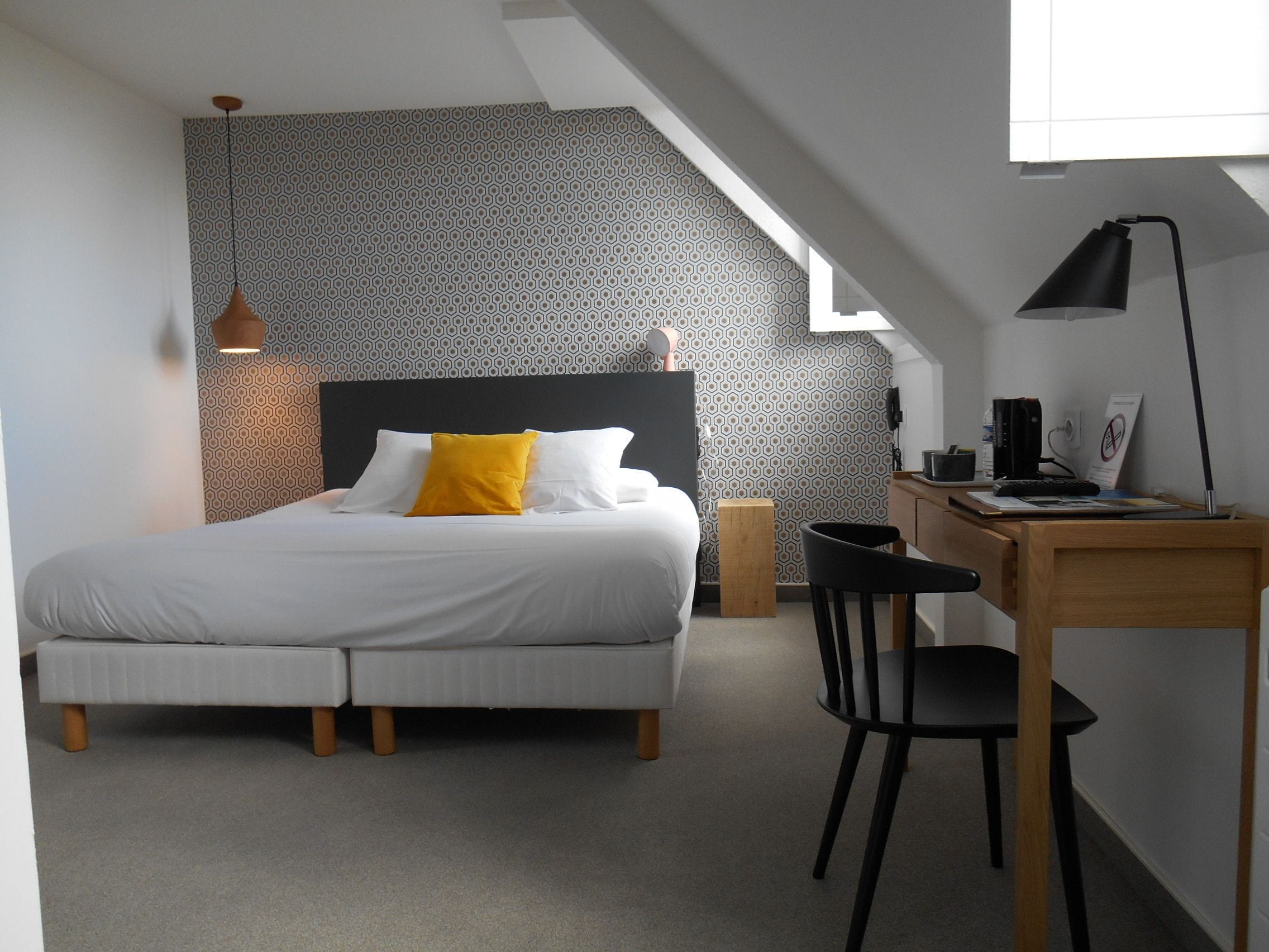 Um quarto moderno com uma cama, uma escrivaninha e uma cadeira.