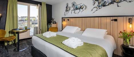 Quarto de hotel com cama, escrivaninha, cadeira, janela com cortinas, luminária na parede e pintura de cavalos.