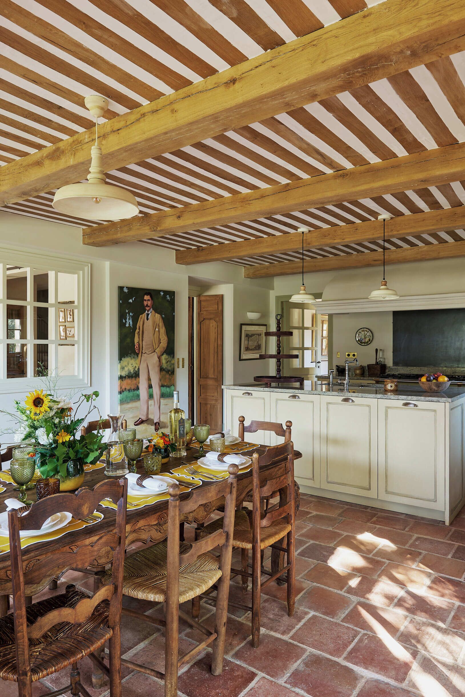 Uma área de refeições com uma mesa de madeira, cadeiras e um quadro de um homem de terno.