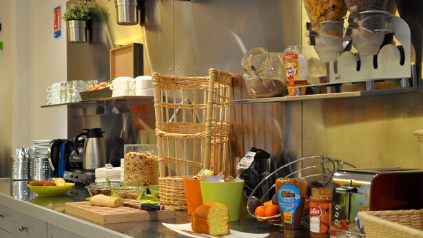 Uma bancada de cozinha com diversos alimentos, utensílios e recipientes.