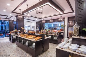 Uma área de buffet com diversos alimentos e um aviso com a inscrição 'Staff Only'.