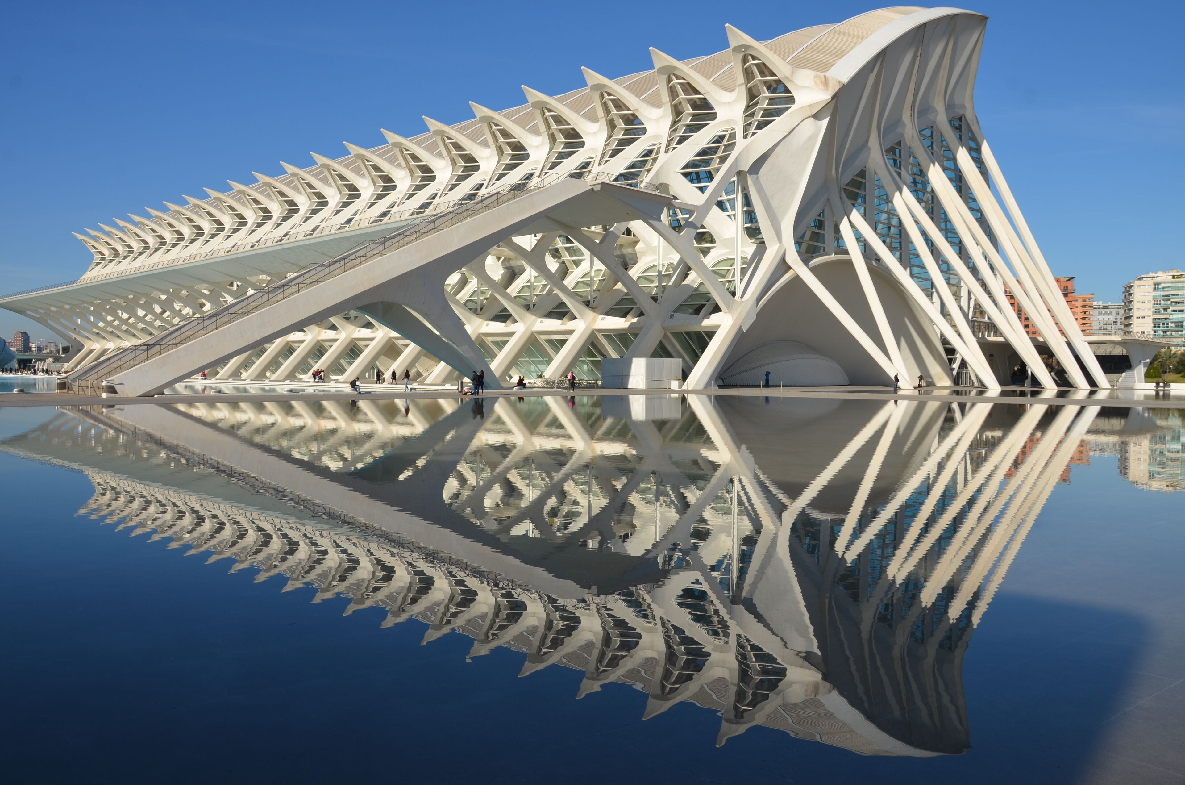Uma estrutura arquitetônica moderna com design único, apresentando uma série de elementos brancos e angulares e uma superfície refletora.