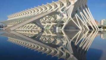 Uma estrutura arquitetônica moderna com design único, apresentando uma série de elementos brancos e angulares e uma superfície refletora.