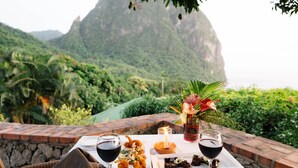 Mesa posta para refeição com vista para montanha e vegetação.