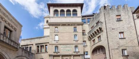 Um edifício histórico com uma entrada arqueada imponente e uma placa com a inscrição