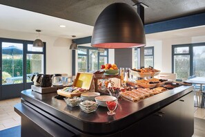 Disposição de buffet com diversos alimentos e uma estação de café.