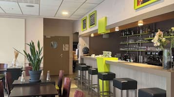 Interior de restaurante com mesas, cadeiras, um bar e um quadro de menu.