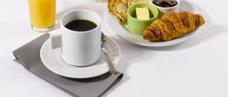 Uma mesa de café da manhã com xícara de café, croissant, panquecas, manteiga, geleia e copo de suco de laranja.